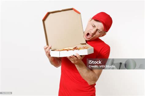 배달 빨간 유니폼을 입고 흰색 배경에 고립 된 사람을 웃 고 모자 티셔츠 택배 또는 골 판지 Flatbox에서 이탈리아 피자를 들고 딜러로 일하고 있는 남자 Pizzaman