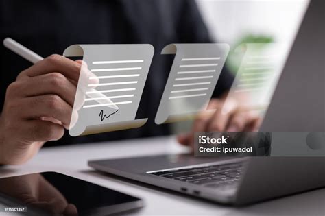 협정 계약서에 서명했습니다 전자 문서 아이콘 전자 문서 관리 온라인 문서 데이터베이스 및 종이없는 사무실의 개념이있는 랩톱 컴퓨터에서 일하는 사업가 보고서에 대한 스톡 사진