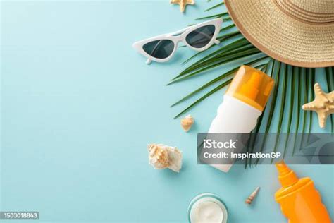 자외선 안전 인식의 달 태양 보호 로션 선글라스 밀짚모자 해양조개껍데기가 복사 공간이 있는 연한 파란색 격리된 배경에 야자수 잎이 있는 높은 각도의 보기 사진 0명에 대한