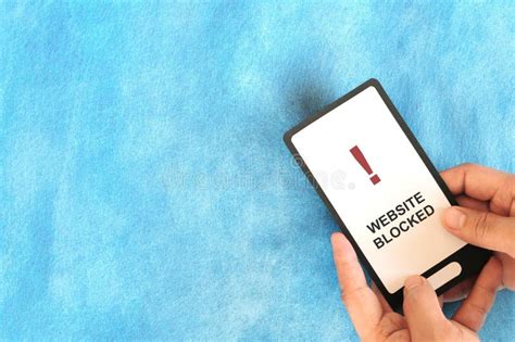 Hand Holding A Mobile Phone With Restricted Site And Website Blocked