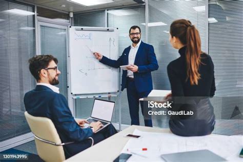 남성과 여성 전문가들은 플립 차트에 인포 그래픽을 확인하는 프로젝트에 대한 설명 문을 위해 코칭 대화를 수익 벤치 마크를 설명 하는 사무실 직원과 통신 하는 사업가 20