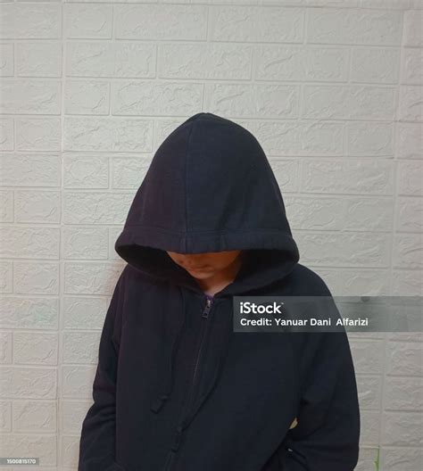 십대 소녀의 고립된 이미지는 후드티를 입고 스튜디오에서 카메라에 포즈를 취하고 있다 아래를 내려다보는 사람의 이미지입니다 십대에