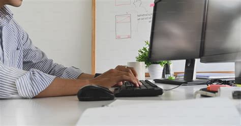 현대 사무실의 업무용 책상에 앉아 키보드로 타이핑하는 젊은 창조적인 사업가의 잘린 샷 사진 Unsplash의 테이블 이미지