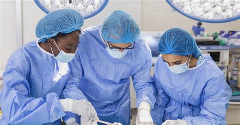 위험한 응급 상황에서 환자를 돕기 위해 작동하는 의사 및 보조 간호사 병원의 응급 수술실에있는 멸균 테이블에있는 수술 도구