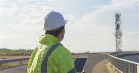 한 남성 엔지니어가 태블릿 분석 엔지니어링 데이터를 사용하여 머리에 보호 헬멧을 쓰고 있습니다 사진 Unsplash의 혁신 이미지