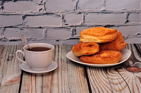 접시에 뜨거운 차 한 잔과 나무 테이블에 과일 마멀레이드가 든 퍼프 페이스트리 몇 개가 담긴 접시 갈색에 대한 스톡 사진 및 기타 이미지 Istock