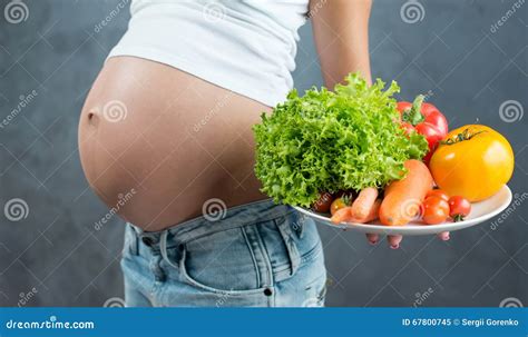 Close Up Of A Cute Pregnant Belly Tummy And Healthy Food Stock Image