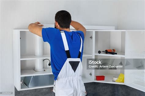 남자는 부엌에 후드와 공기 덕트를 설치하고 덕트의 일부를 실란트와 접착제로 연결합니다 30 34세에 대한 스톡 사진 및 기타 이미지 30 34세 Stem 주제 가구