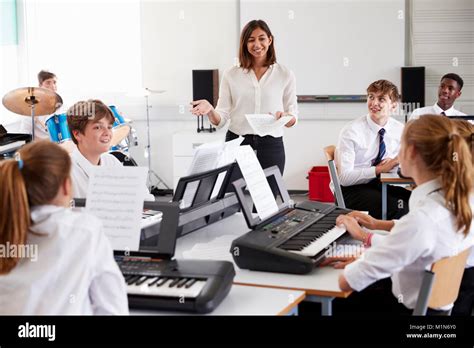 Teenage Students Studying Electronic Keyboard In Music Class Stock