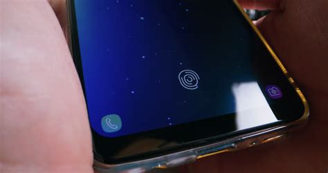 close up shot of man logging into phone using fingerprint reader stock