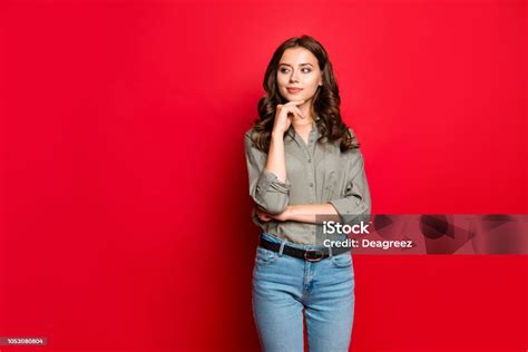 청바지에 블라우스 보고 옆으로 밝은 빨간색 배경에 텍스트 복사 공간에 고립 된 아름 다운 사랑 스러운 잘생긴 곱슬 갈색 머리 여자의 초상화 가냘픈에 대한 스톡 사진 및 기타