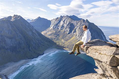 남성 등산객은 로포텐 섬의 매달린 바위 해변 산 전망에 앉아 있다 30 34세에 대한 스톡 사진 및 기타 이미지 30 34세 건강한 생활방식 경관 Istock