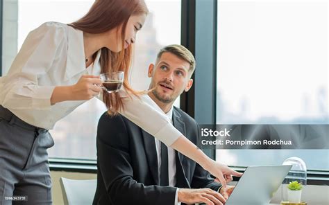 잘 생긴 사업가와 아름다운 여자 또는 비서가 정장을 입고 아침에 사무실에서 함께 일이나 프로젝트에 대해 논의하고 노트북을