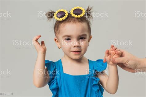 선글라스를 끼고 하얀 배경에 스튜디오에 있는 파란 정장을 입은 금발의 여자 아기 아이 어린 시절 헤어 롤빵 헤어 스타일 여름 패션 2 3 살에 대한 스톡 사진 및 기타