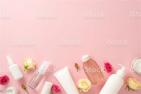 파스텔 핑크 배경에 펌프 병 피펫 크림 병 장미를 보여주는 평면도 평면 레이로 부드러운 스킨케어의 아름다움을 경험하십시오 빈