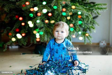 크리스마스 트리에서 휴일 장식을 복용 귀여운 아기 소녀 가벼운 화환을 들고 있는 아이 축하 후 가족 제거 및 나무를 폐기 12월에 대한 스톡 사진 및 기타 이미지 Istock