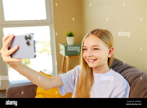 Pre Teen Girl Making Selfie Photos On Her Smartphone In Cozy Living