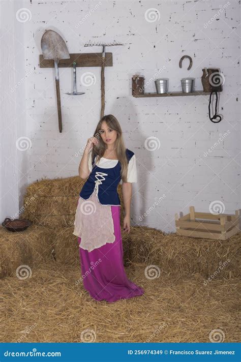 Beautiful Young Woman Dressed In Farmer Outfit In Barn With Hay Stock
