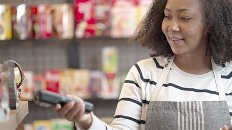 슈퍼마켓에서 일하는 아프리카 계 미국인은 바코드 스캐너를 사용하거나 선반에 남아있는 제품 수를 확인하고 식료품 점에서 제품을