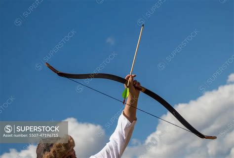 Archer In Traditional Clothes Shooting An Arrow Superstock