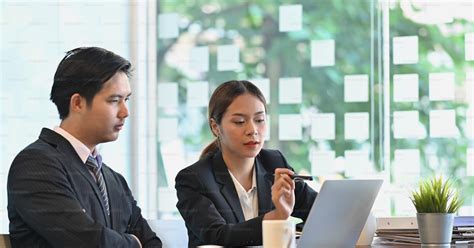 자신감 넘치는 사업가가 현대 사무실의 회의실에 앉아 옆에 있는 동료에게 새로운 프로젝트를 설명하고 있다 사진