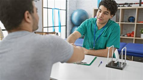 A Male Therapist In Uniform Listens Attentively To A Male Patient In A