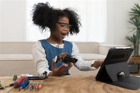 집에서 프로젝트 장난감 로봇 기술을 배우고 구축하는 여학생 교실에서 아프리카 계 미국인 어린이 소녀 훈련 및 제어 장난감 로봇 6 7 살에 대한 스톡 사진 및 기타 이미지