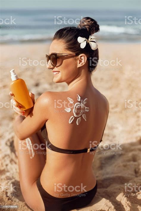 피부 관리 자외선 차단 소녀는 선크림을 바릅니다 심장의 형태로 수영장에서 선탠 로션을 가진 여자 어깨에 그려진 태양이 있는 여성의 초상화 선크림 립밤에 대한 스톡 사진 및