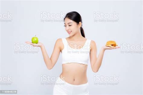 흰색 배경에 고립 된 신선한 샐러드 야채와 햄버거를 선택하는 다이어트와 아름다운 젊은 아시아 여성 슬림 모양 칼로리 영양 및