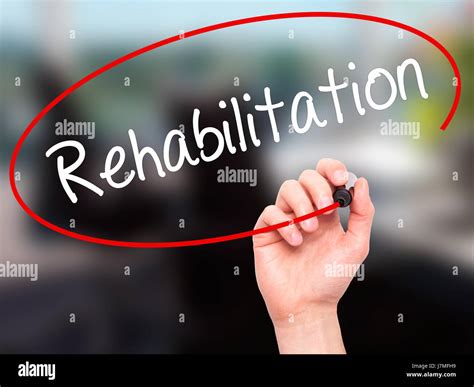 Man Hand Writing Rehabilitation With Black Marker On Visual Screen Isolated On Office Business