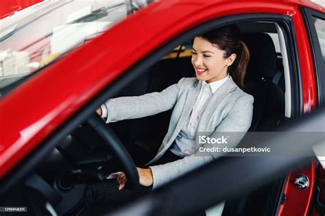 자동차 살롱에서 차에 앉아 그녀가 사고 싶은 차를 시도하는 미소 여자 첫 자동차에 대한 스톡 사진 및 기타 이미지 첫 자동차 소비자 경험 차 Istock