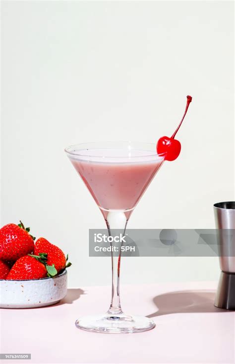 보드카 리큐어 크림 시럽 딸기 및 얼음을 칵테일 체리와 함께 유리에 넣은 현상금 마티니 여름 알코올 칵테일 음료 베이지 핑크 바닐라 배경 데킬라 독한 술에 대한 스톡 사진