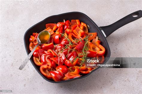 얇게 썬 빨간 피망 양파 신선한 타임 꿀 숟가락을 베이지색 질감의 배경에 얹은 프라이팬 맛있는 고추 타르트 또는 기타 야채 요리를 요리하는 단계 0명에 대한 스톡 사진 및