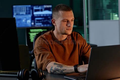 Young Male Software Developer Coding On Laptop While Sitting At Working