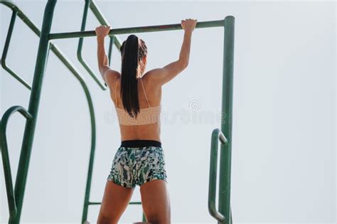 Active Woman Exercising Outdoors Motivated Doing Pull Ups In A Park