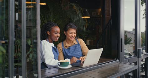 노트북 계획 및 비즈니스 소유자 팀이 커피숍에서 재고 관리 또는 회의를 위해 함께 모입니다 카페 협업 및 컴퓨터 행복한 동료 여성과 함께 식당 창에서 토론 계획에 대한 스톡