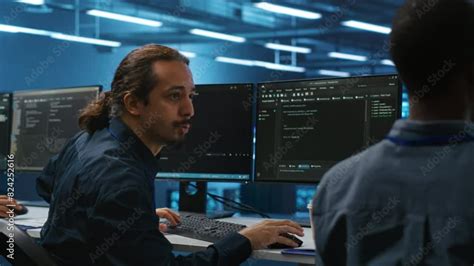 Engineers Coding Together In High Tech Server Hub Using Computers To