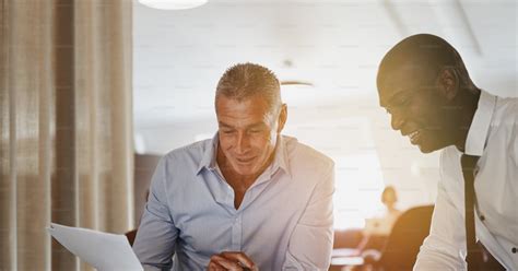 현대적인 사무실에 함께 앉아 노트북을 통해 서류 작업에 대해 논의하는 두 명의 다양한 사업가 사진 Unsplash의 덴마크 이미지