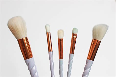 흰색 배경에 촬영 6 메이크업 브러시의 세트 그 중 5개는 함께 그룹화되고 그림 왼쪽에 있는 더 큰 파우더 브러시로 균형을