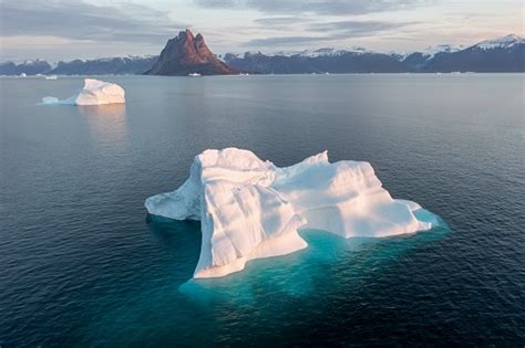 대서양의 큰 빙산 Ilulissat Icefjord 그린란드 서부 일출의 푸른 바다와 푸른 하늘 그린란드 해안의 빙산이 녹는 아름다운 여름날 지구 온난화 Tunu에 대한