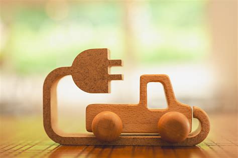 전선과 리튬 배터리가 있는 목조 자동차 연결된 충전 케이블이 있는 기술 배터리 고출력 전기 에너지 깨끗한 전기로 전기 자동차 및 모바일 장치에 배터리 전기 자동차 대체 연료