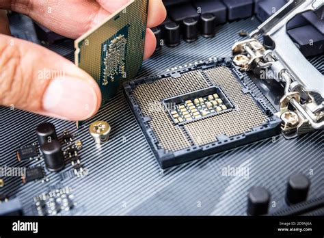 Closeup Detail Of CPU Chip Over Socket With Hand Of A Modern Computer Black Motherboard