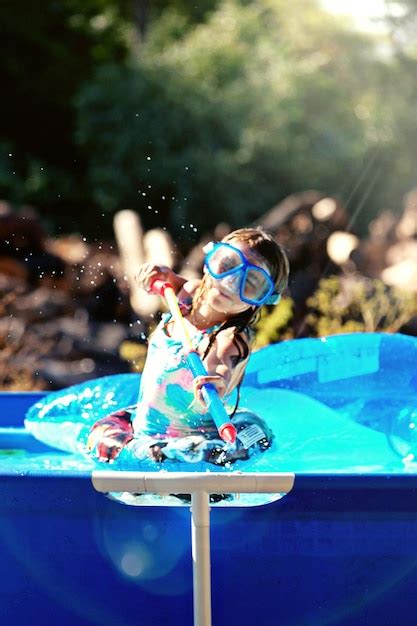 Premium Photo Girl Spraying Water From Gun In Slide At Park