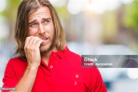 격리 된 배경 찾고 스트레스와 긴장에 긴 머리를 가진 젊은 잘생긴 남자는 손톱을 물어 뜯고 입에 손 불안 문제입니다 감정에 대한 스톡 사진 및 기타 이미지 Istock