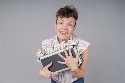 예쁜 여자는 스튜디오에서 돈으로 가득 찬 가방을 들고있다 격리된 회색 배경입니다 귀여운에 대한 스톡 사진 및 기타 이미지 귀여운 금융 긍정적인 감정 표현 Istock