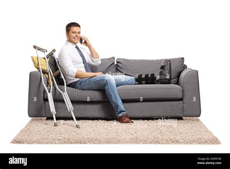 Businessman With A Foot Injury And Leg Brace Sitting On A Sofa And