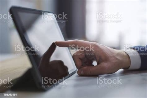 밝은 흐릿한 사무실 배경에 책상 위에 있는 현대 디지털 태블릿 화면을 만지는 남성 손가락의 근접 촬영 가리키기에 대한 스톡 사진 및 기타 이미지 Istock