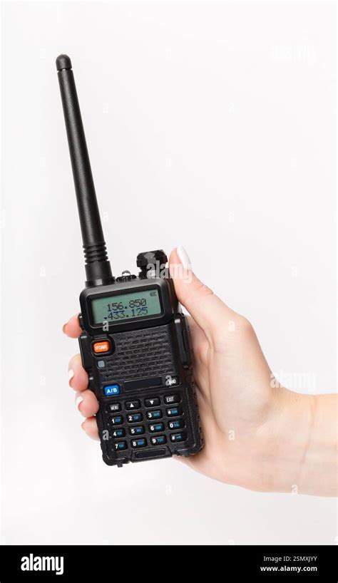 Handheld Radio Communicator Held By A Person With A Visible Display And