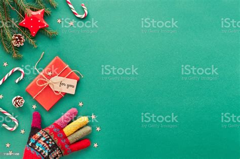 창조적 인 크리스마스 플랫 은 복사 공간 녹색 종이에 녹색과 빨간색에 배경을 누워 화려한 울 장갑 사탕 지팡이 공예 종이 태그