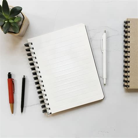 Minimalist Workspace With Open Notebook And Stationery Items Premium AI Generated Image
